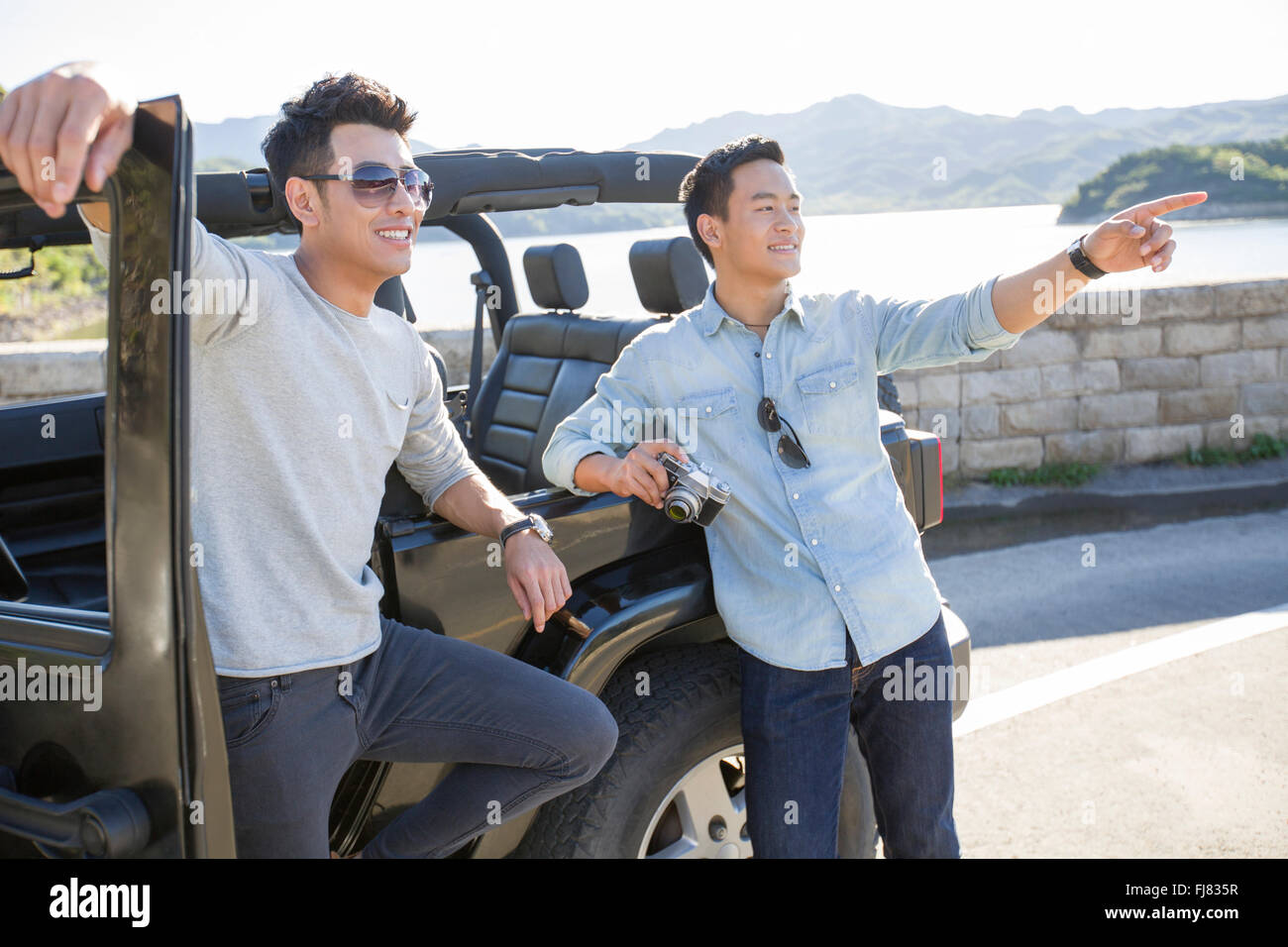 Happy young Chinese men and jeep Stock Photo - Alamy