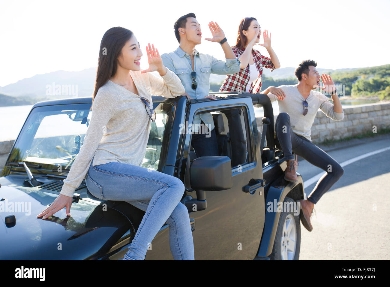 Chinese friends having fun in a jeep Stock Photo - Alamy
