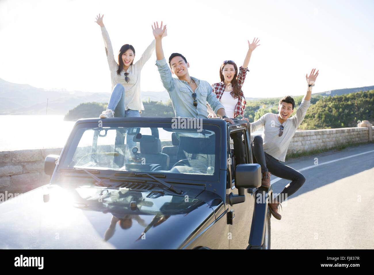 Chinese friends having fun in a jeep Stock Photo - Alamy