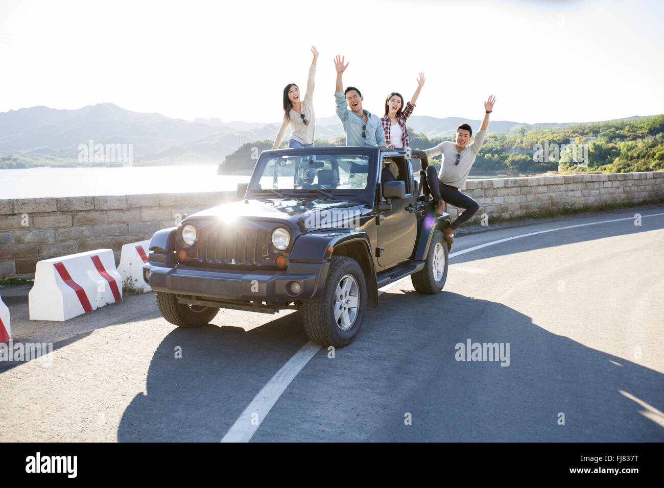 Chinese friends having fun in a jeep Stock Photo - Alamy