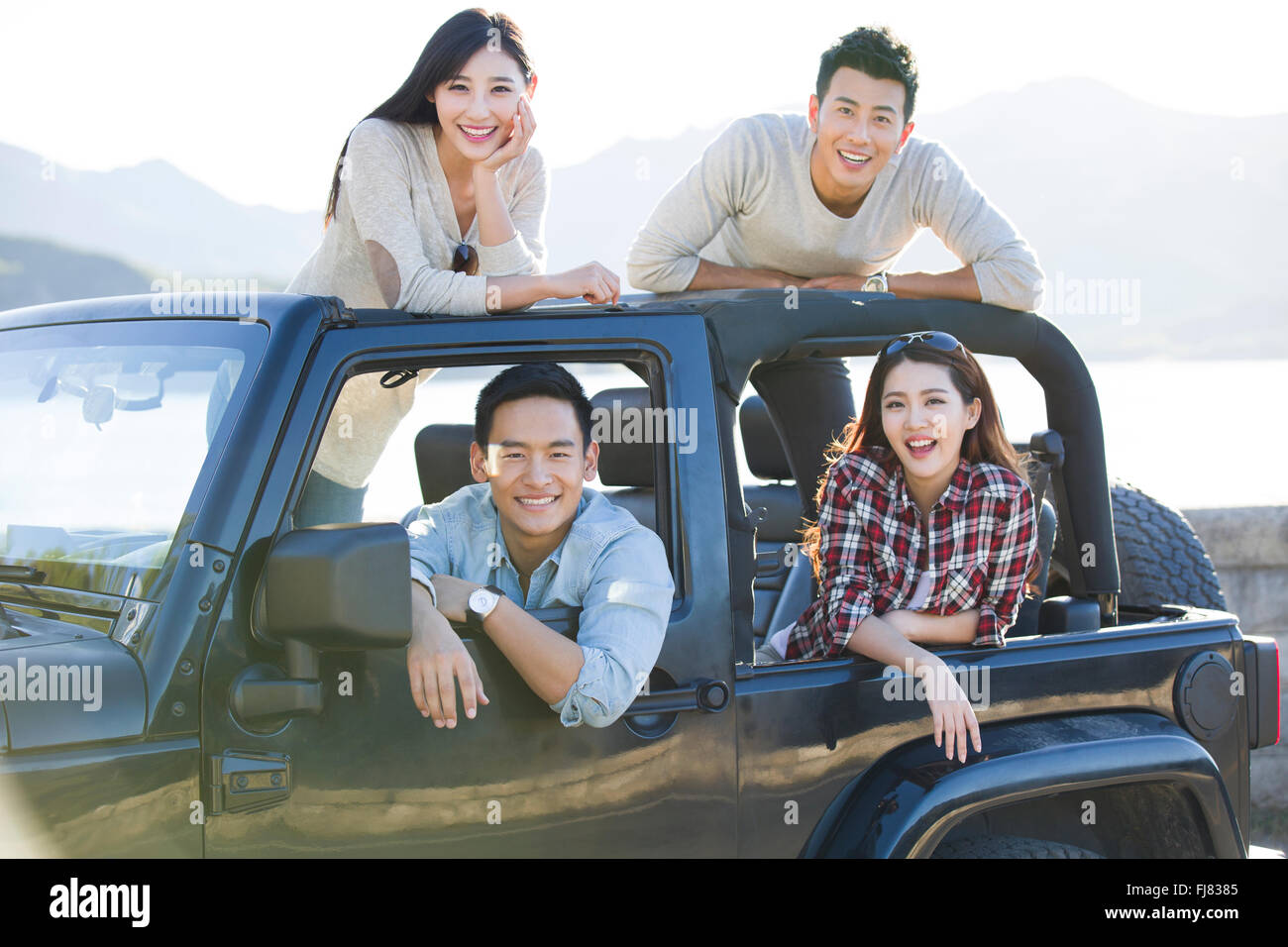 Chinese friends having fun in a jeep Stock Photo - Alamy