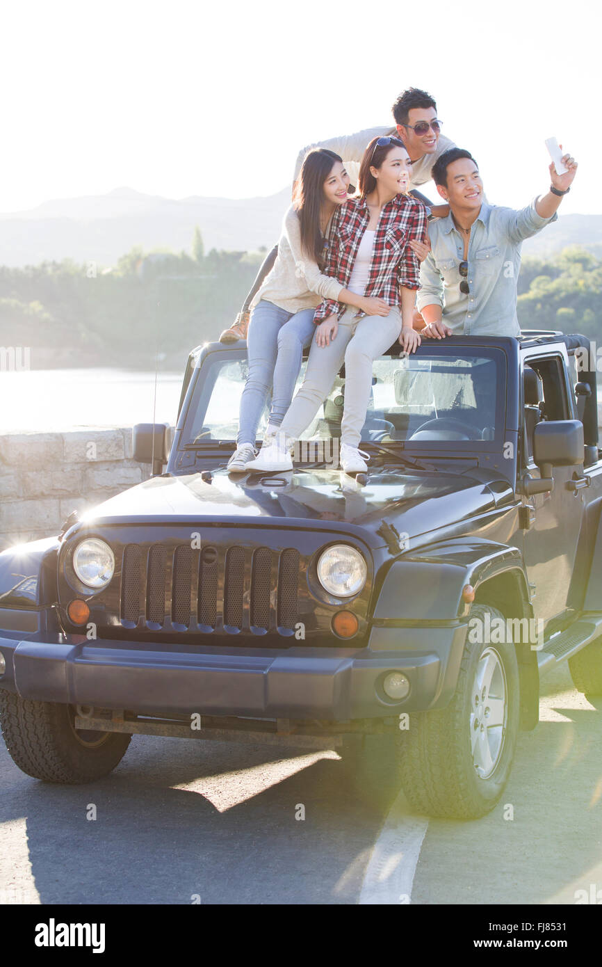 Chinese friends having fun in a jeep Stock Photo - Alamy