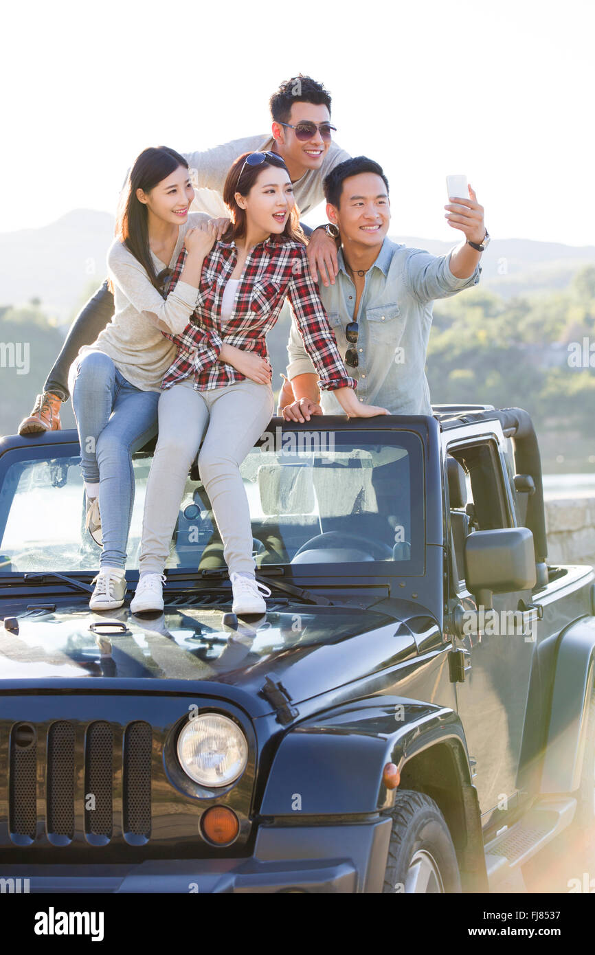 Chinese friends having fun in a jeep Stock Photo - Alamy