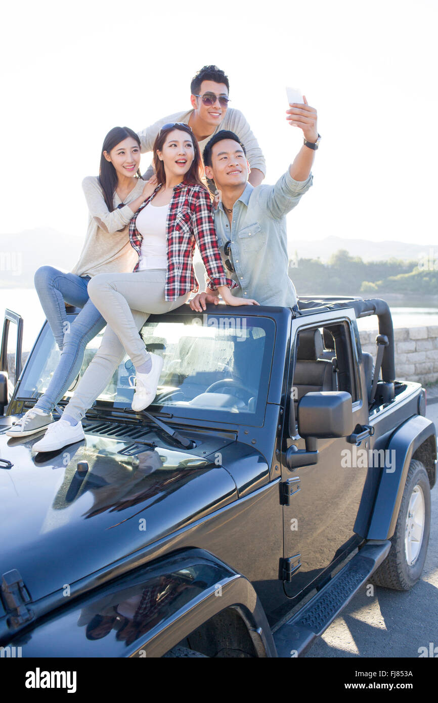Chinese friends having fun in a jeep Stock Photo - Alamy