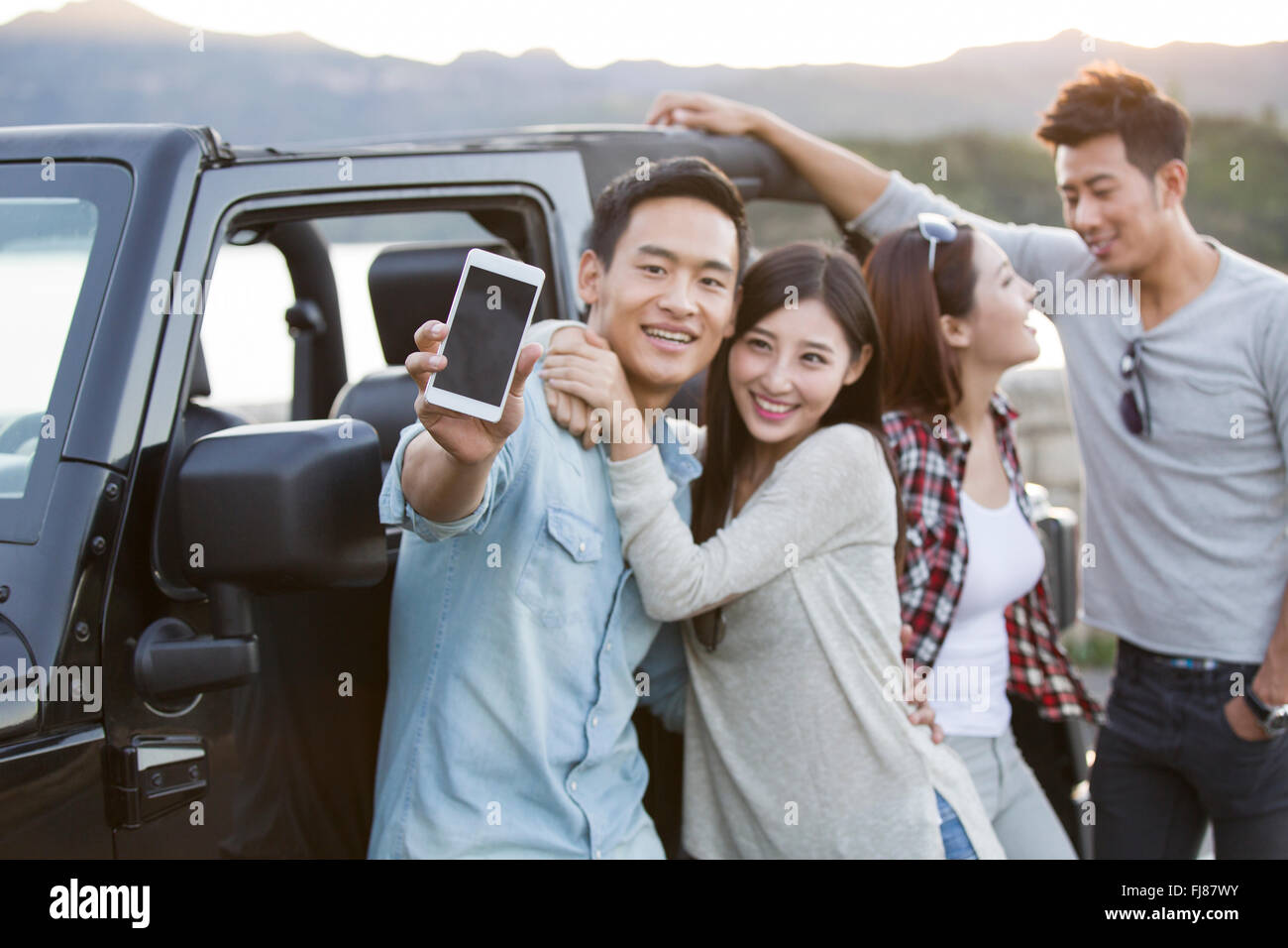 Happy Chinese friends and jeep Stock Photo - Alamy