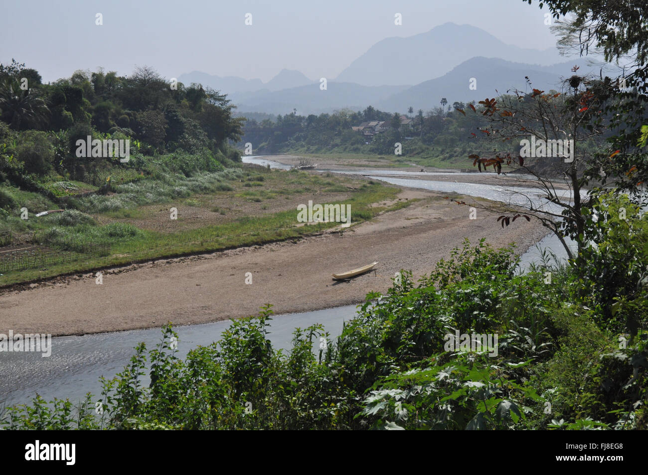 Traditional boat and mountains: Nam Kham River, Luang Prabang, Laos ...