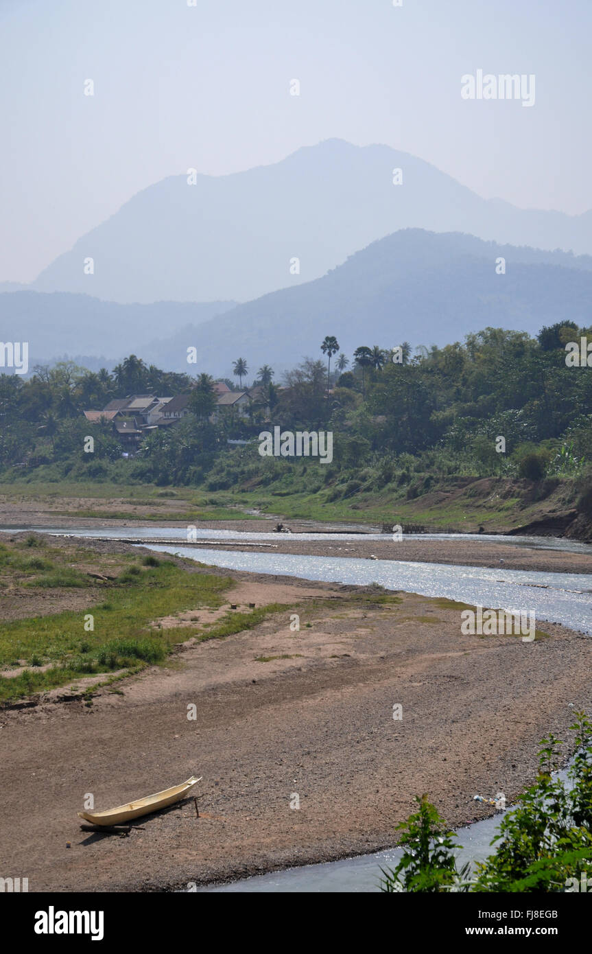 Traditional boat and mountains: Nam Kham River, Luang Prabang, Laos ...
