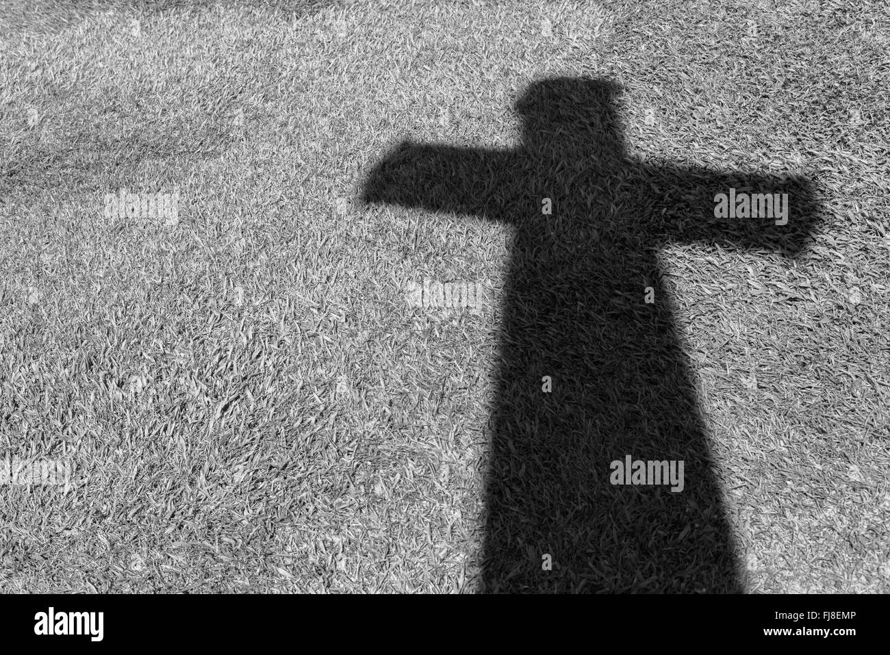 Shadow of Christian cross on green grass floor in Black and white style ...