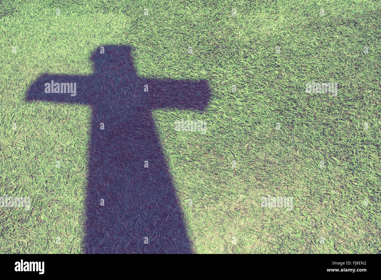 Shadow of Christian cross on green grass floor with Vintage filter ...