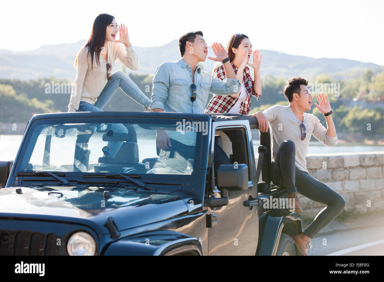 Chinese friends having fun in a jeep Stock Photo - Alamy