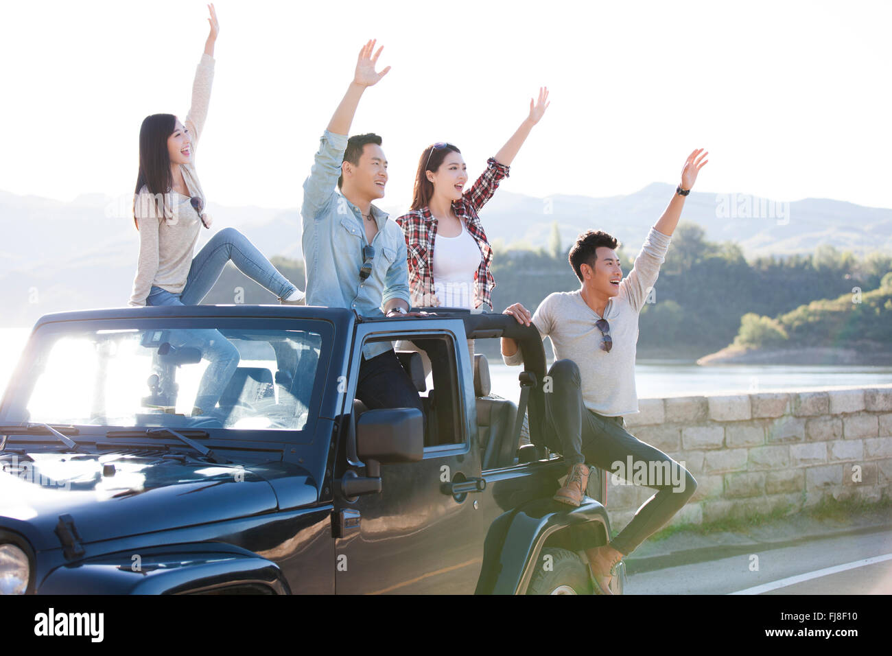 Chinese friends having fun in a jeep Stock Photo - Alamy