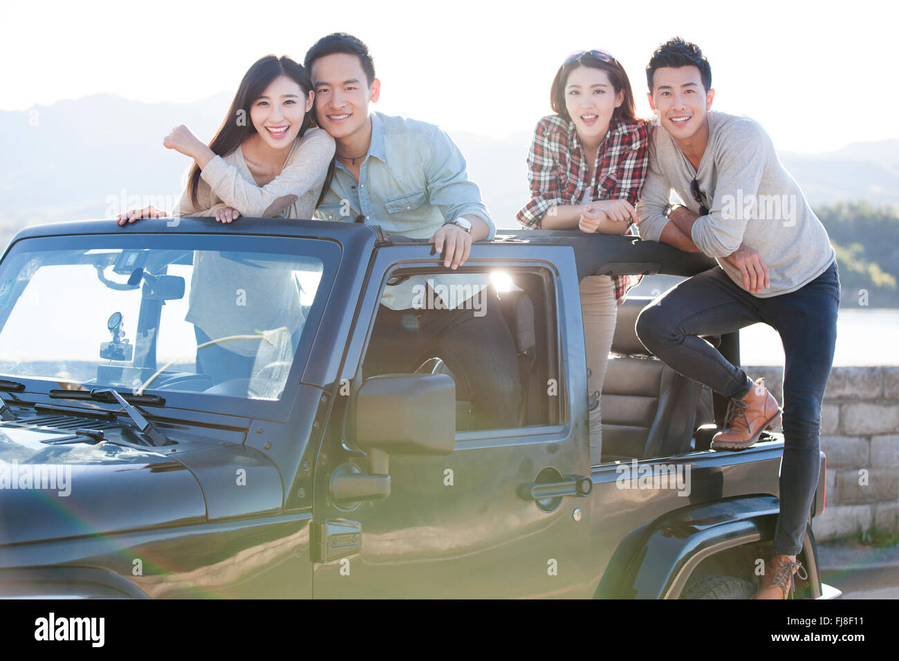 Chinese friends having fun in a jeep Stock Photo - Alamy