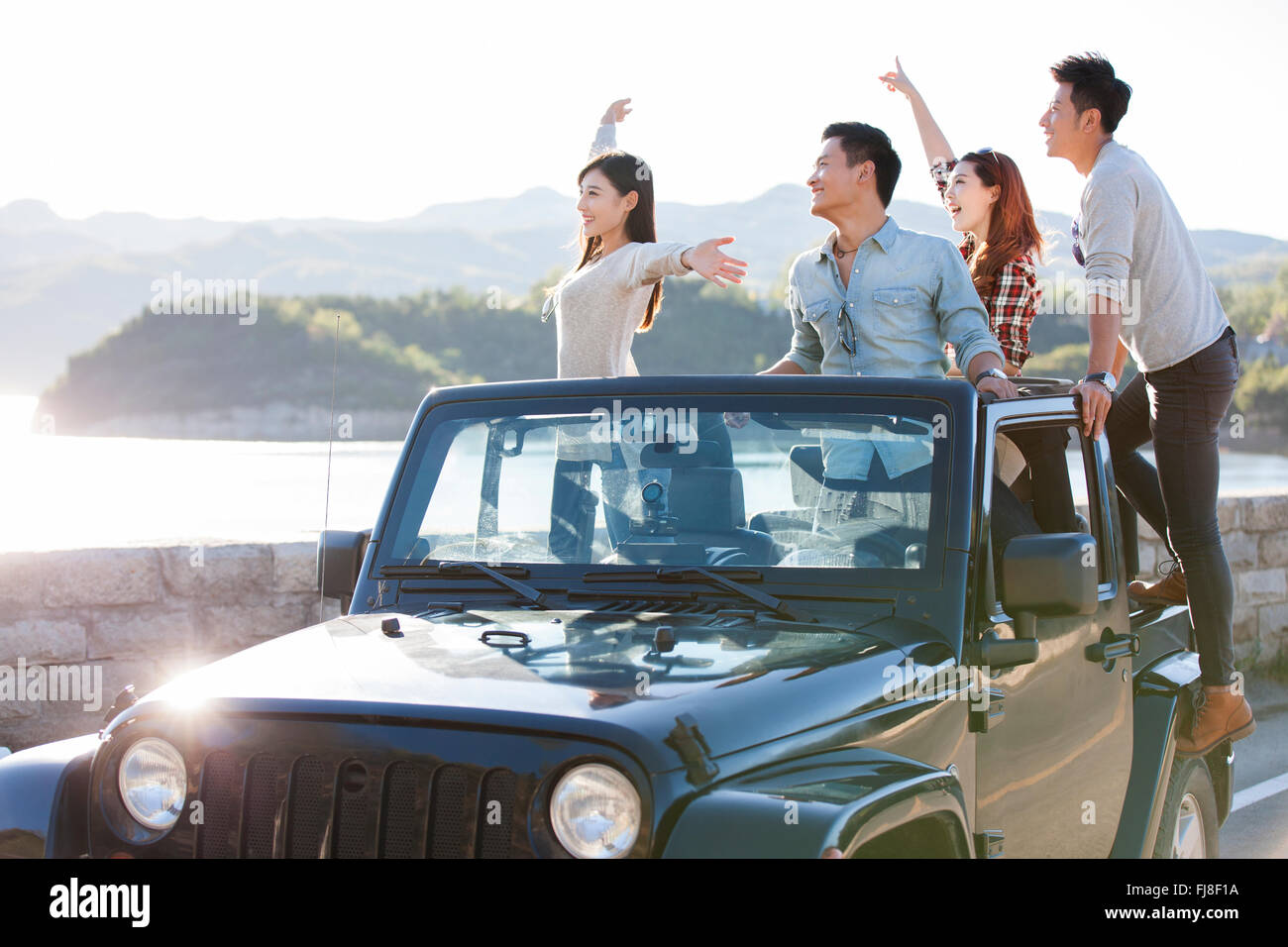 Chinese friends having fun in a jeep Stock Photo - Alamy