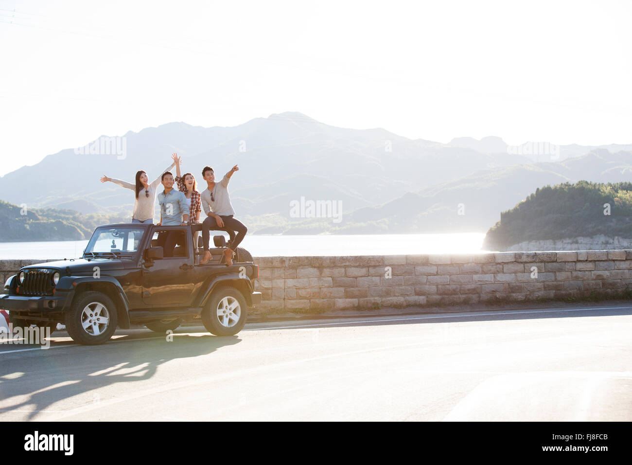 Chinese friends having fun in a jeep Stock Photo - Alamy
