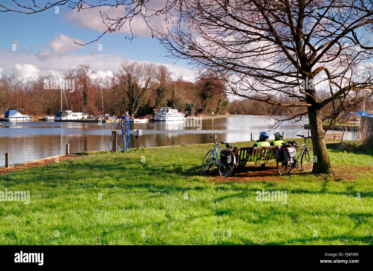 Two elderly male cyclists resting on a bench at Barton Turf Staithe on ...