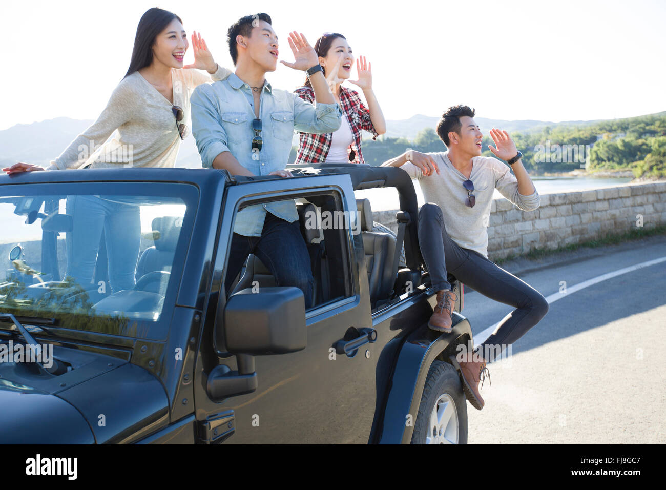 Chinese friends having fun in a jeep Stock Photo - Alamy