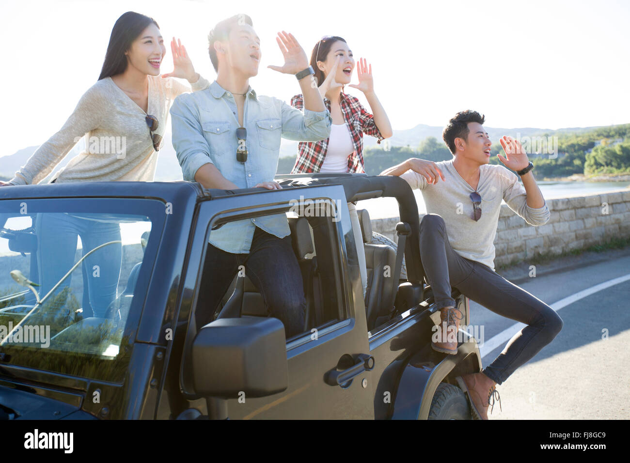 Chinese friends having fun in a jeep Stock Photo - Alamy