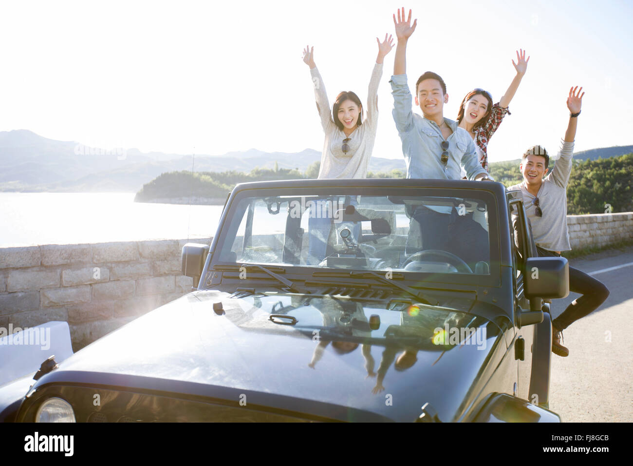 Chinese friends having fun in a jeep Stock Photo - Alamy