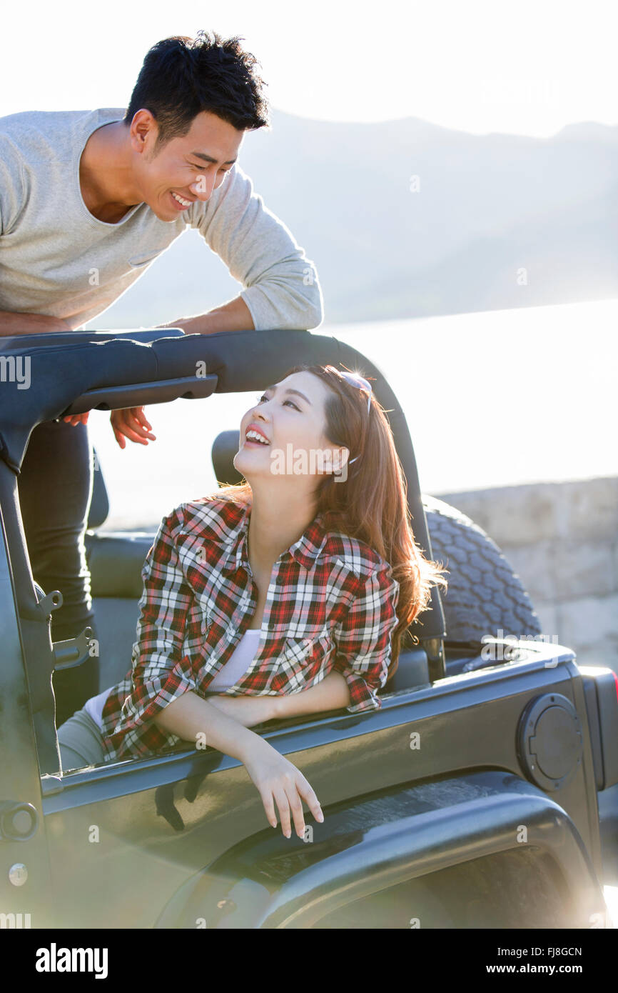 Young Chinese couple having fun in a jeep Stock Photo - Alamy