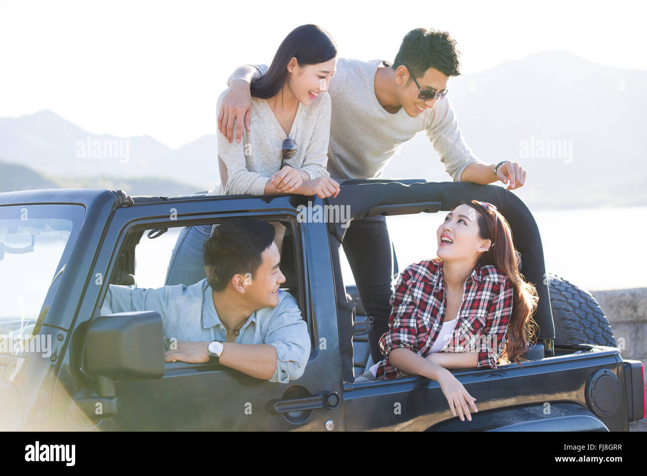 Chinese friends having fun in a jeep Stock Photo - Alamy
