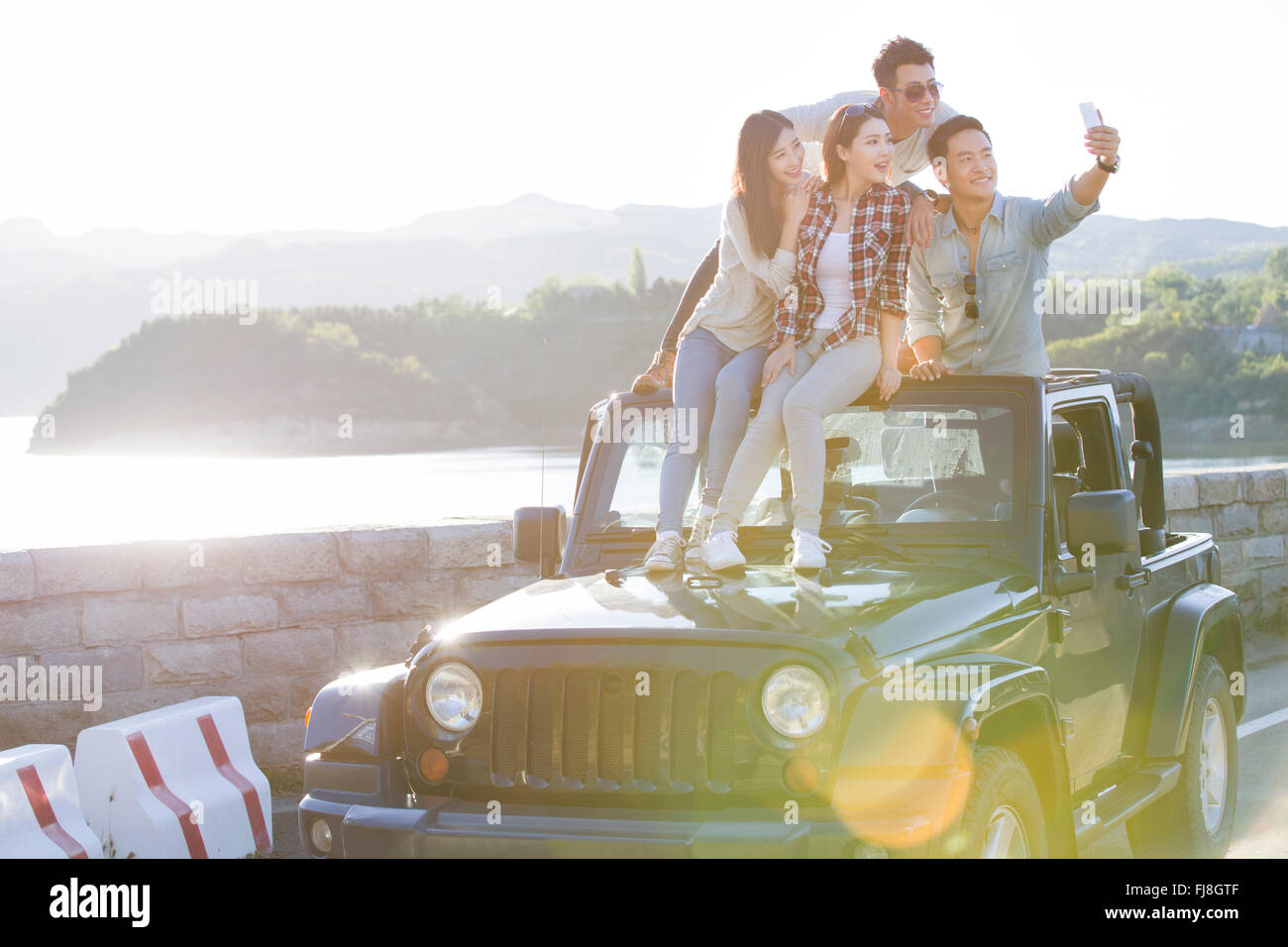 Chinese friends having fun in a jeep Stock Photo - Alamy