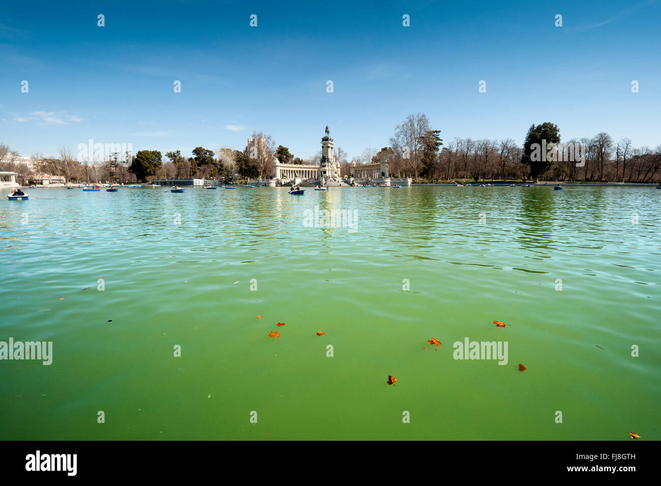Lake in Retiro Park, Madrid, Spain. At the background, the Monument to ...