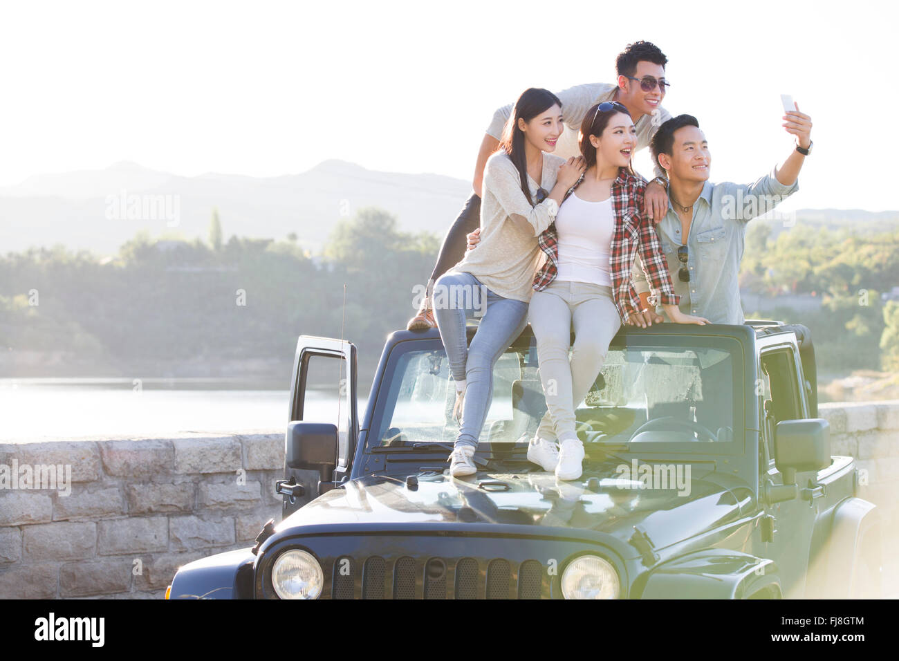 Chinese friends having fun in a jeep Stock Photo - Alamy