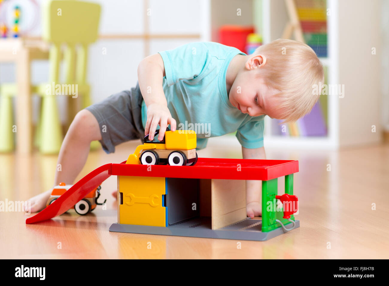 Little child playing with a toy car in nursery Stock Photo - Alamy