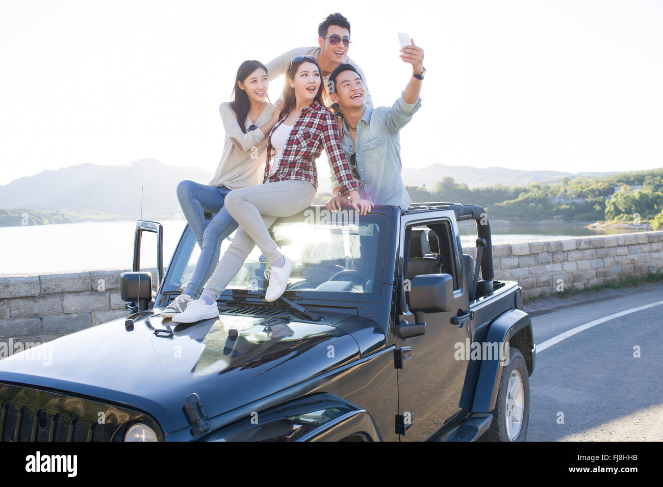 Chinese friends having fun in a jeep Stock Photo - Alamy