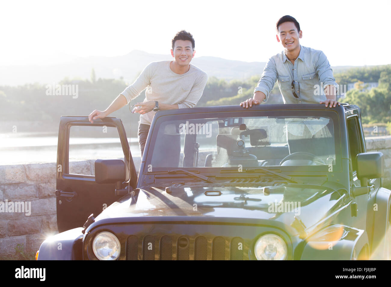Happy young Chinese men and jeep Stock Photo - Alamy