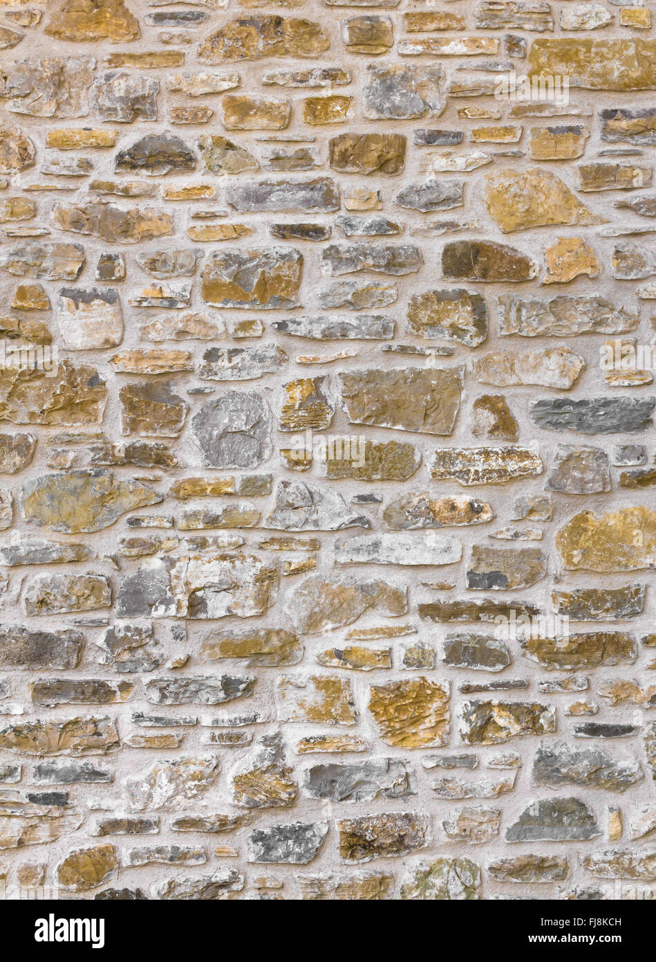 Old irregular golden stone wall, background Stock Photo - Alamy