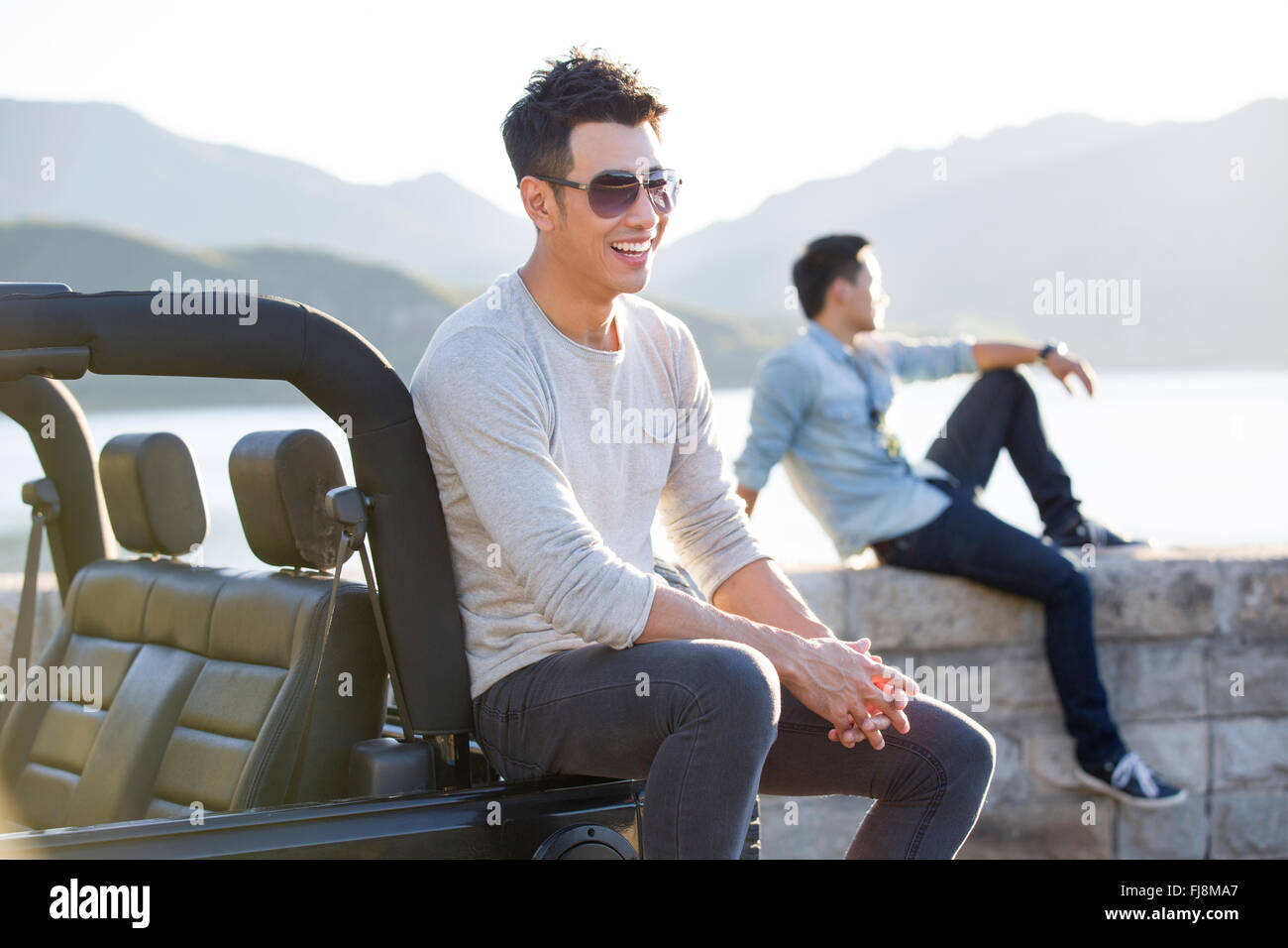 Happy young Chinese men and jeep Stock Photo - Alamy