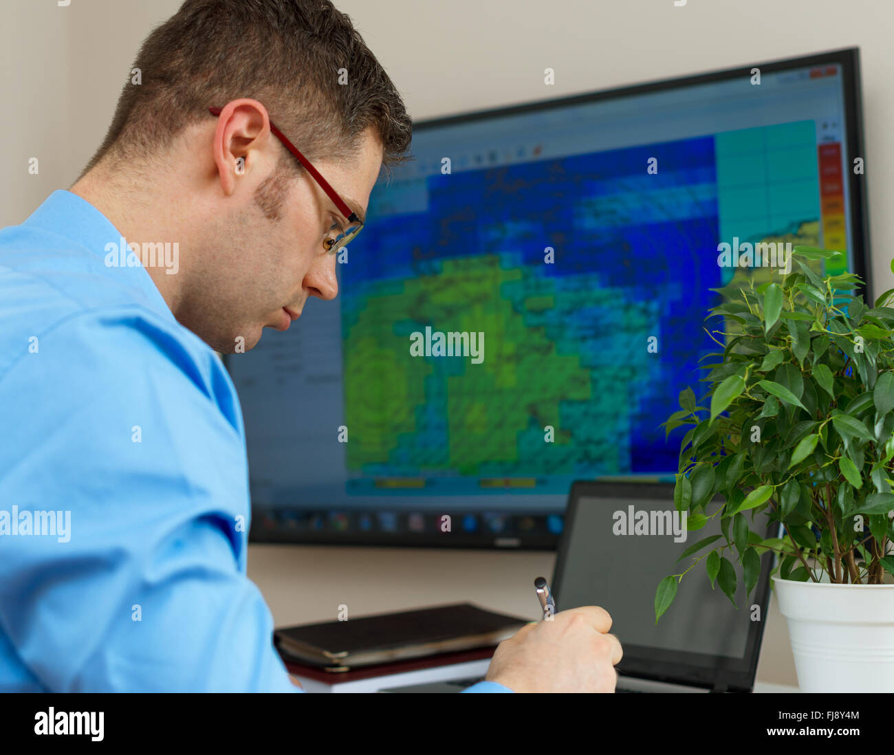 Handsome male meteorologist in glasses thinking Stock Photo - Alamy