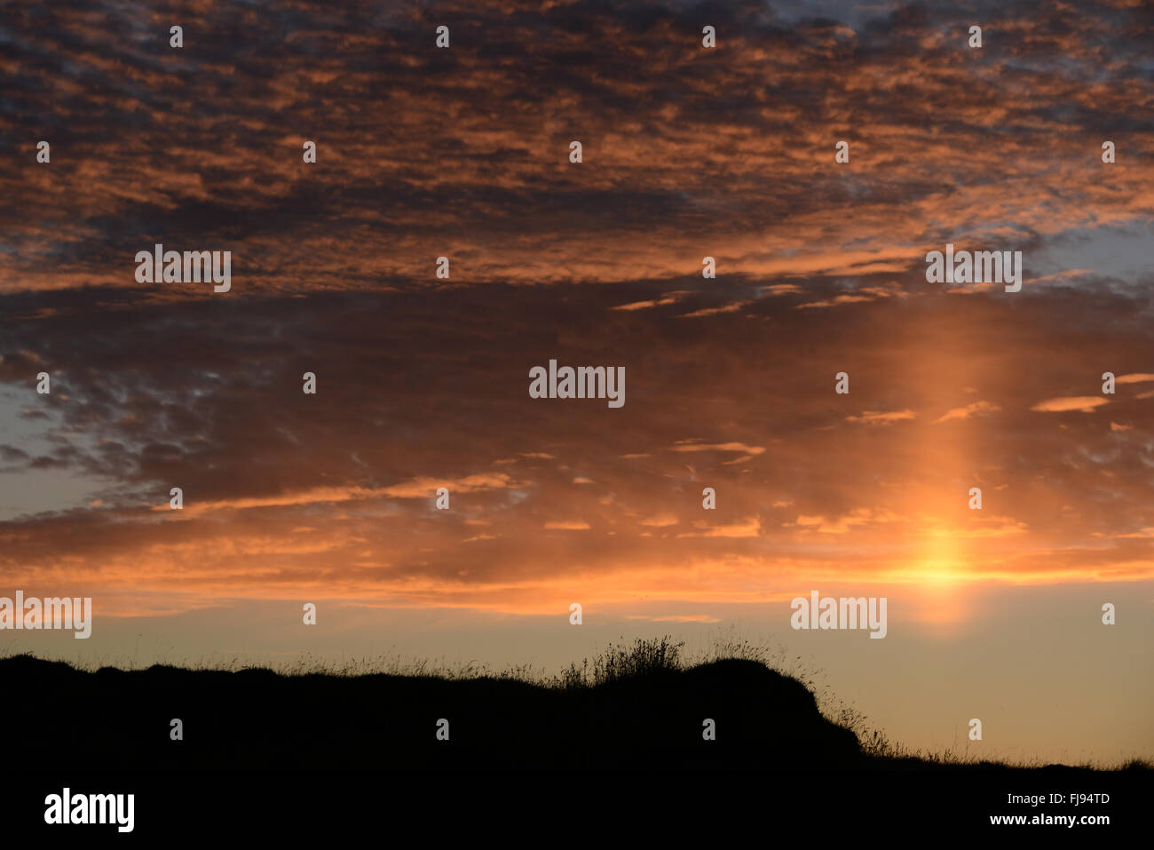 Unusual sun pillar at sunset on South Uist, Outer Hebrides. The focus ...