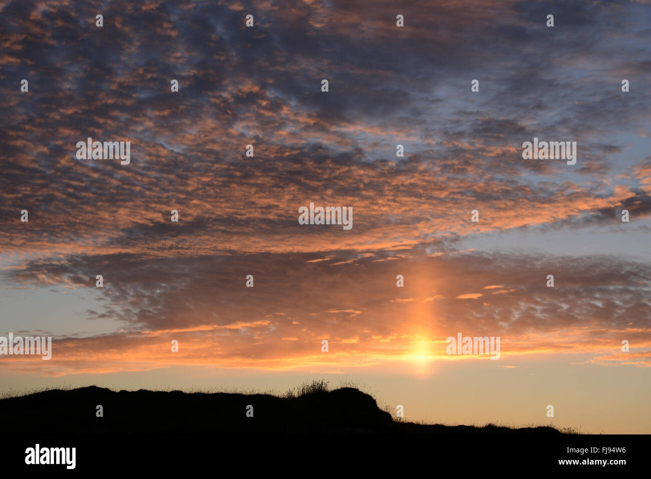 Unusual sun pillar at sunset on South Uist, Outer Hebrides. The focus ...