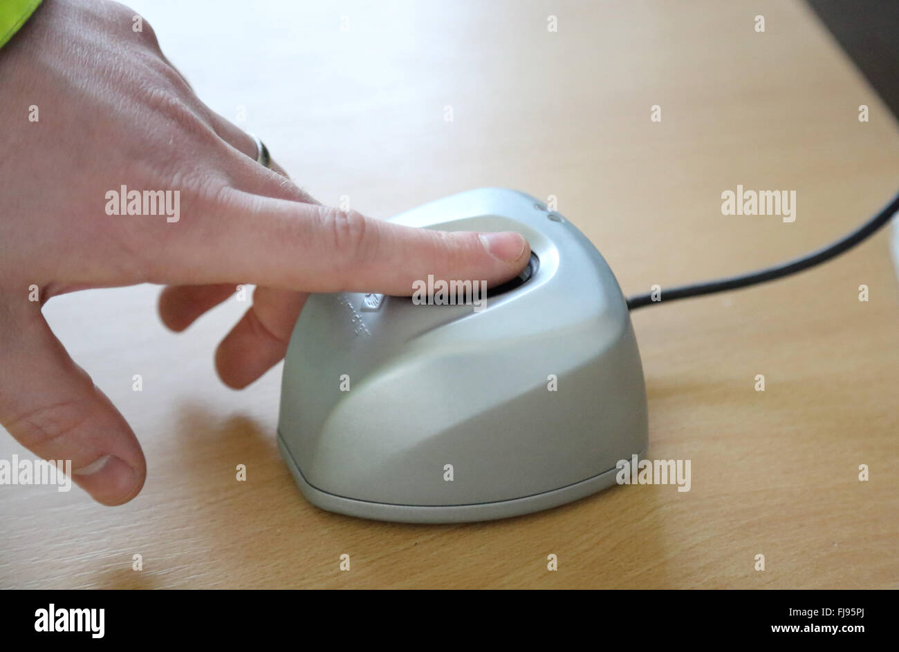 A construction worker places his index finger on a fingerprint reader ...