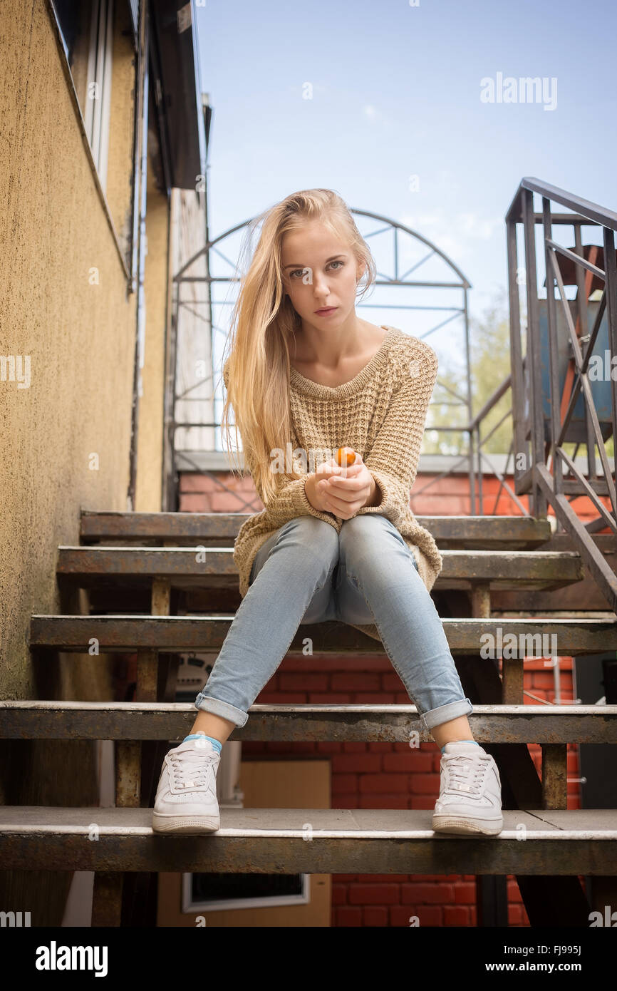 sad young woman sitting on steps Stock Photo - Alamy