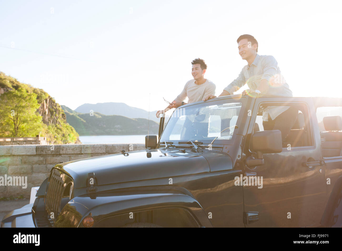 Chinese friends having fun in a jeep Stock Photo - Alamy
