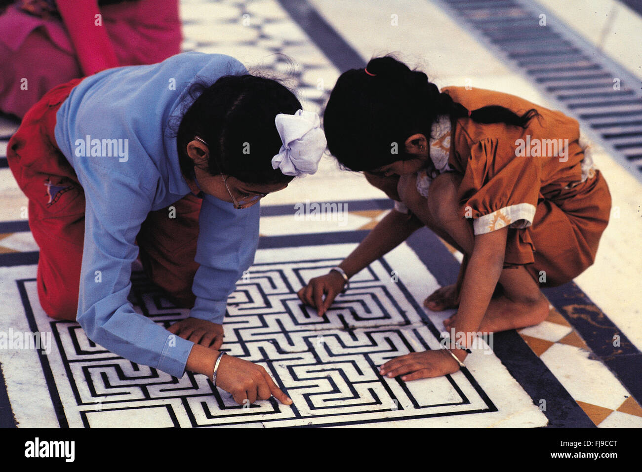 Children playing maze game on marble floor, boy and girl playing maze ...