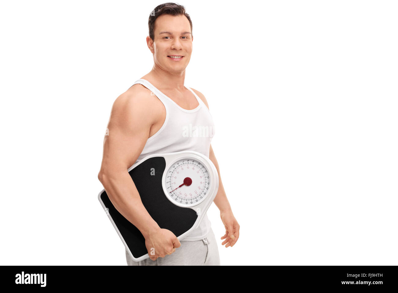 Muscular man holding a weight scale and looking at the camera isolated ...