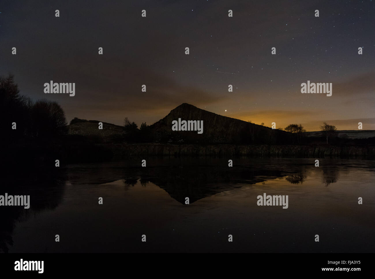 Cawfields Quarry and lake at night. The Whin Sill of the Quarry is ...