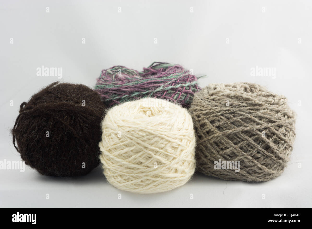 Balls of hand spun wool on a white background Stock Photo - Alamy