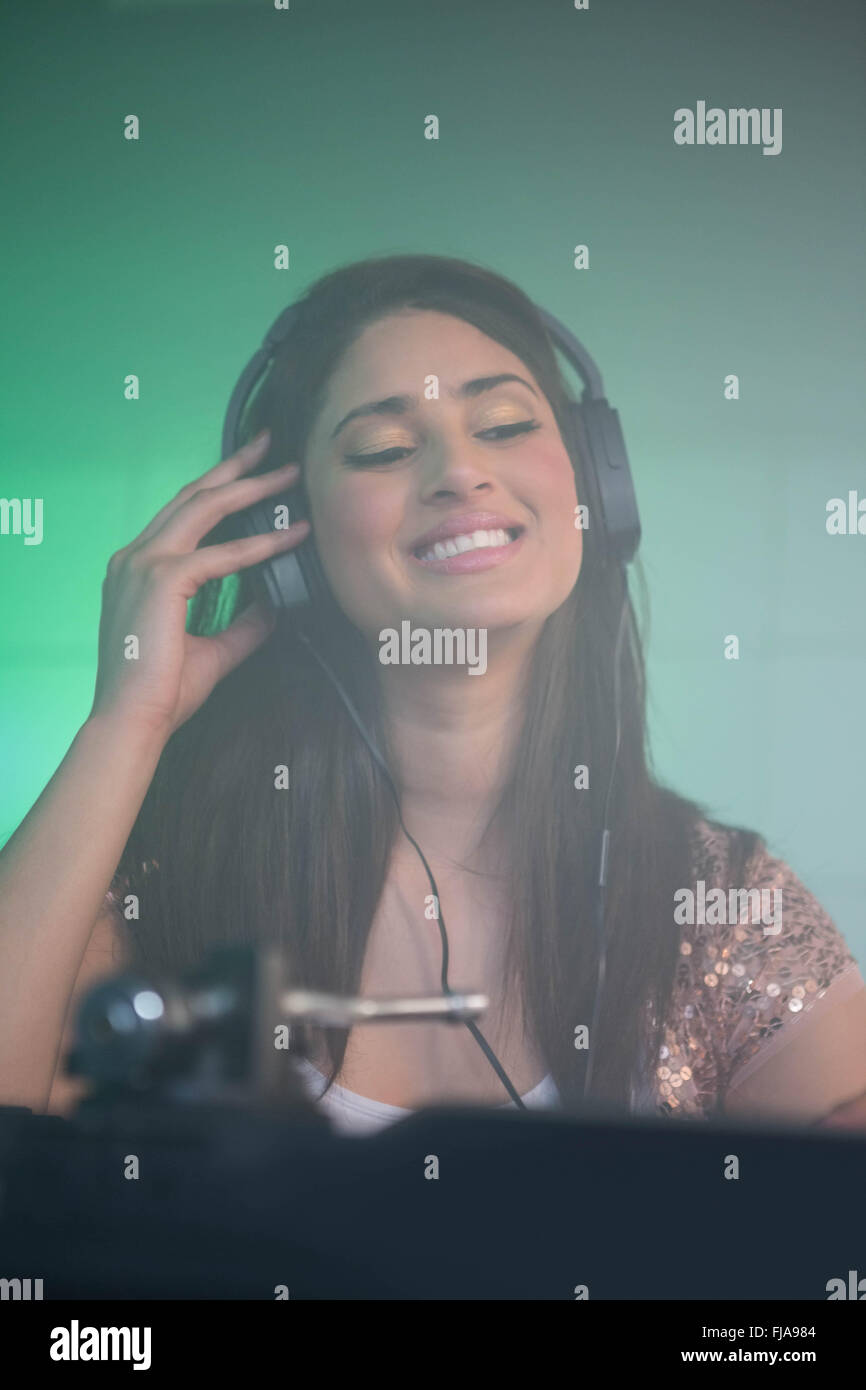 Pretty female DJ playing music Stock Photo - Alamy