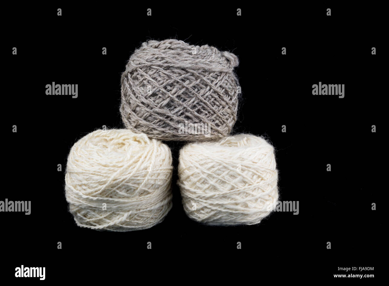 Three balls of wool on a black background Stock Photo - Alamy