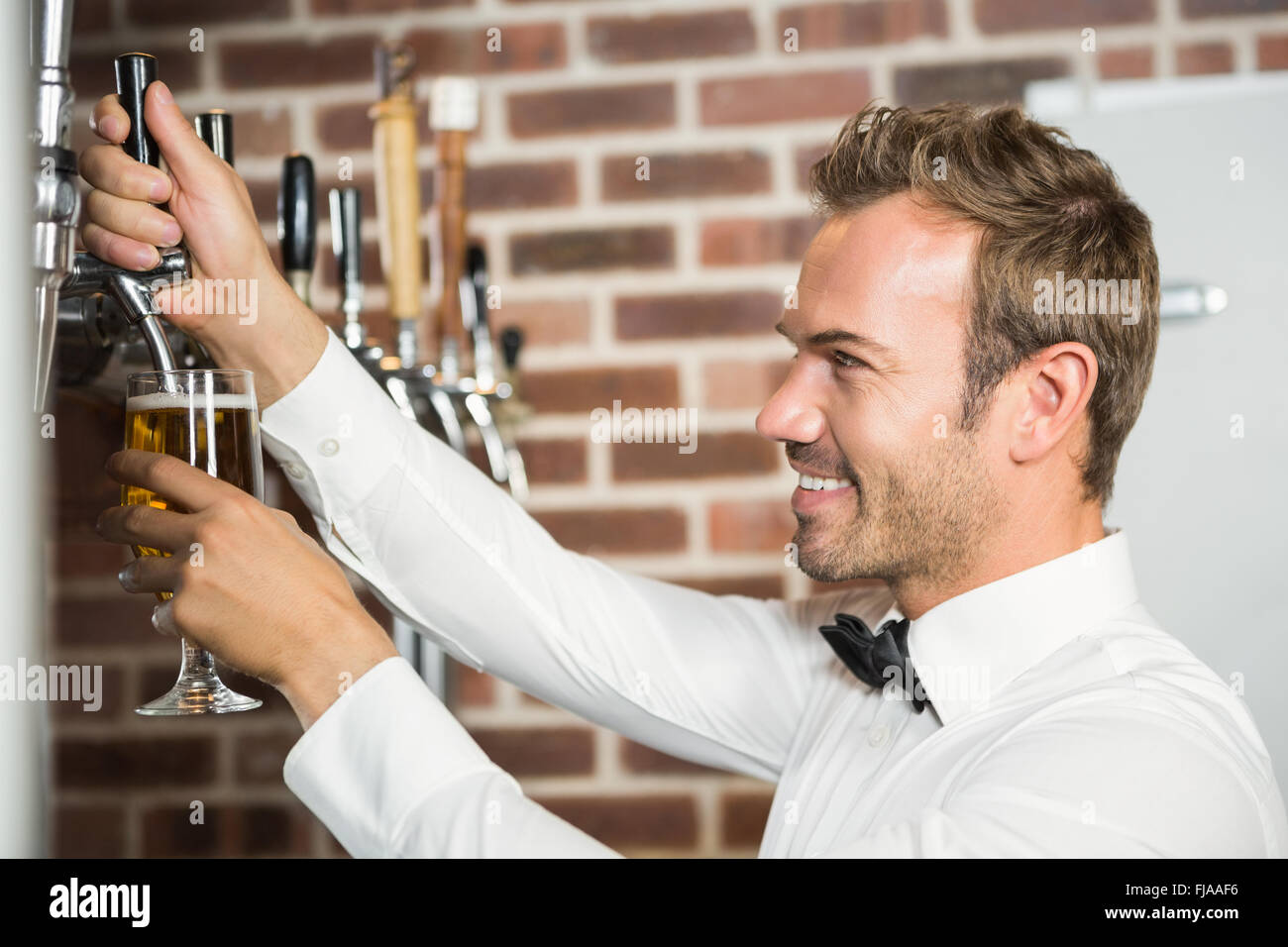 Handsome barman pouring a pint of beer Stock Photo - Alamy
