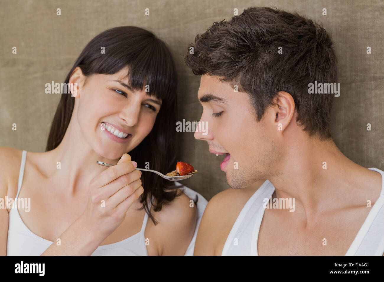 Woman feeding breakfast cereals to man Stock Photo - Alamy