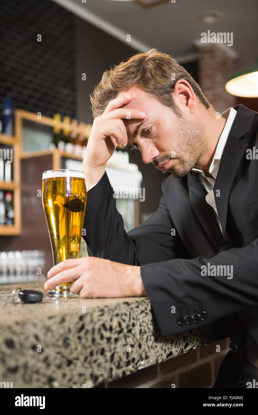 Tired man having a beer Stock Photo - Alamy
