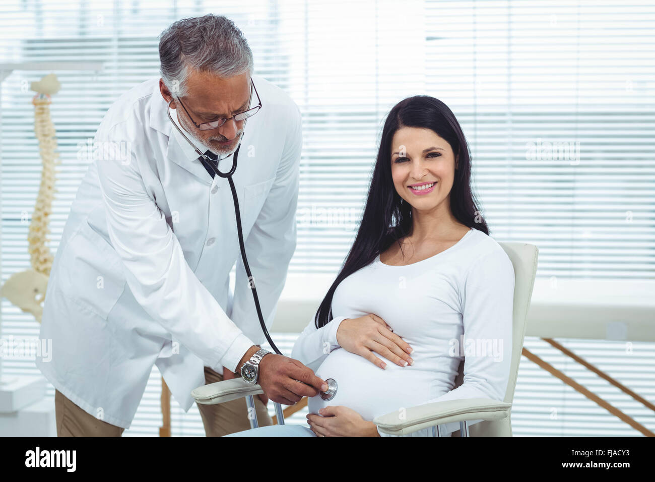 Doctor examining pregnant woman with a stethoscope Stock Photo - Alamy