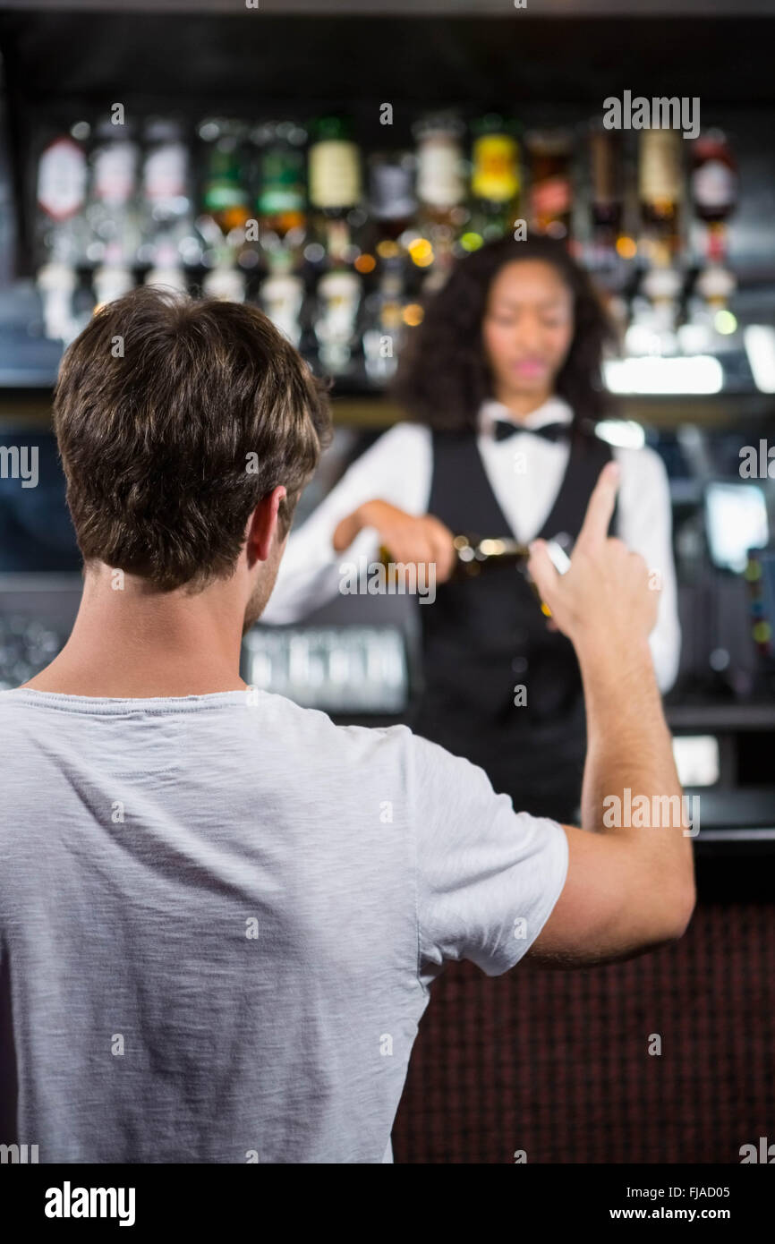 Man ordering a drink at bar counter Stock Photo - Alamy
