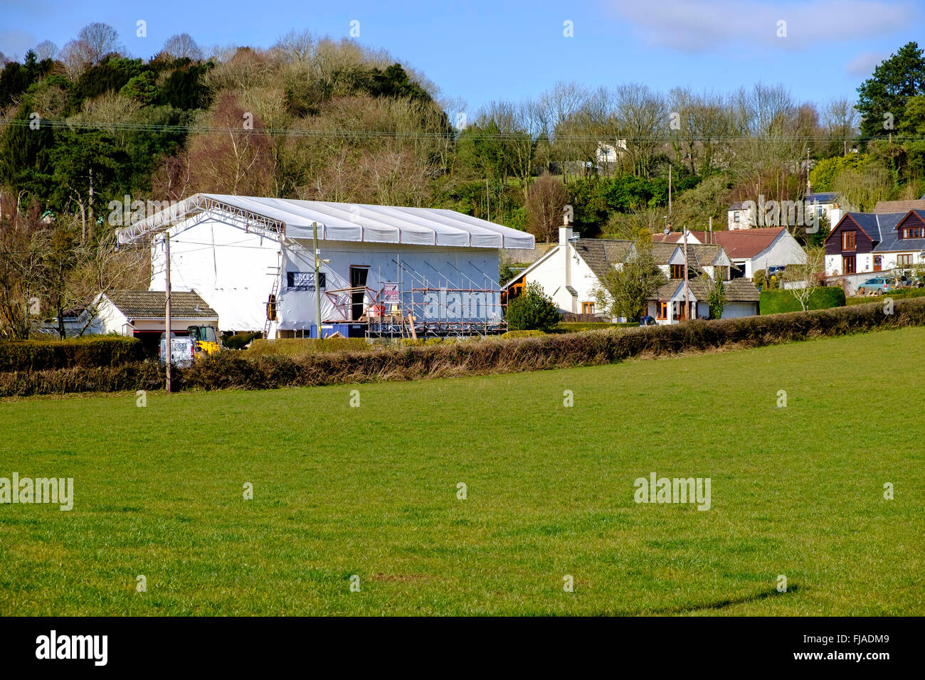 House covered in plastic sheeting while building work is going on ...
